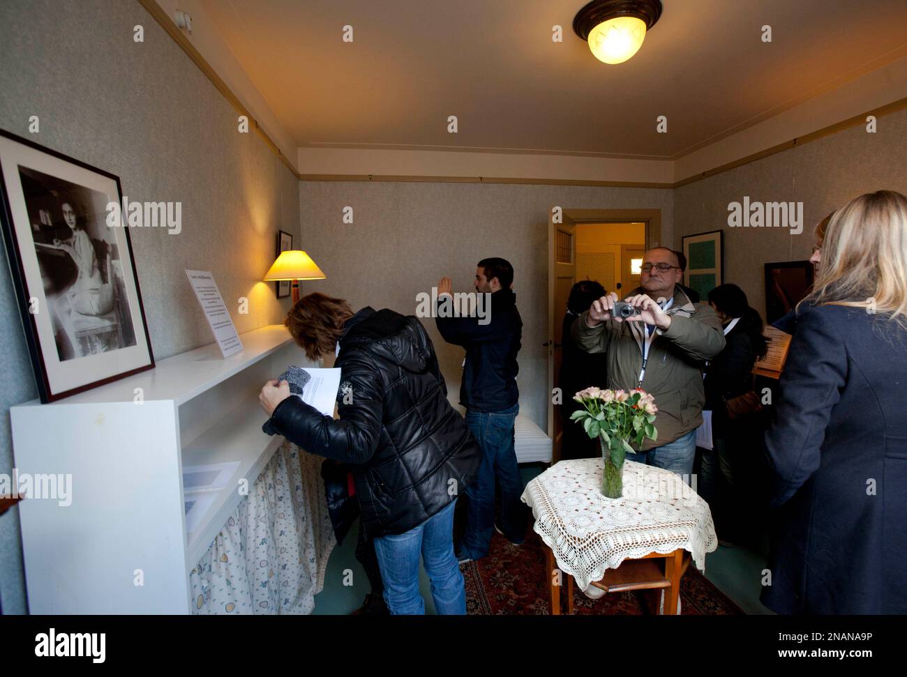A picture of Anne Frank is seen in her bedroom as visitors tour the ...