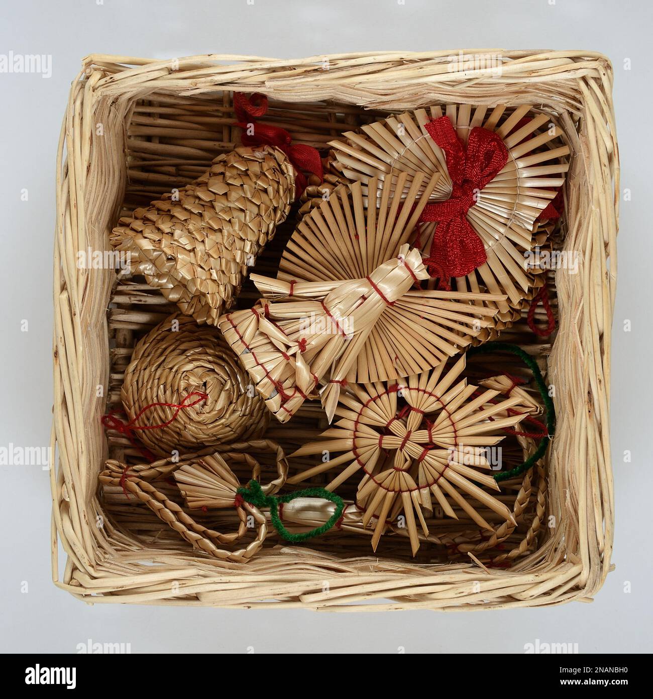 traditional Christmas straw decorations in a wicker box on a neutral ...