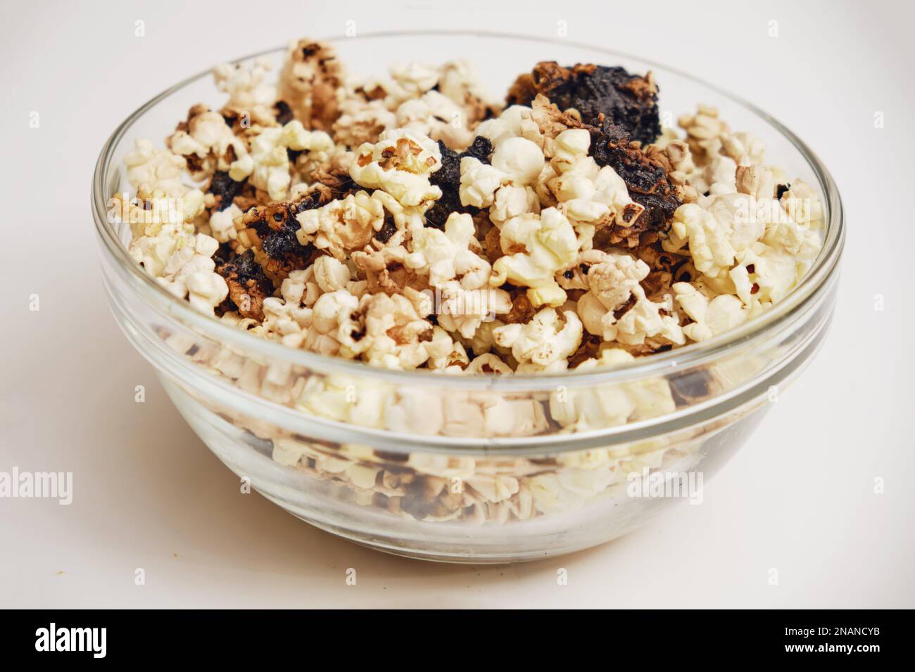 Burnt popcorn from a home microwave. Burn corn kernels on the kitchen ...
