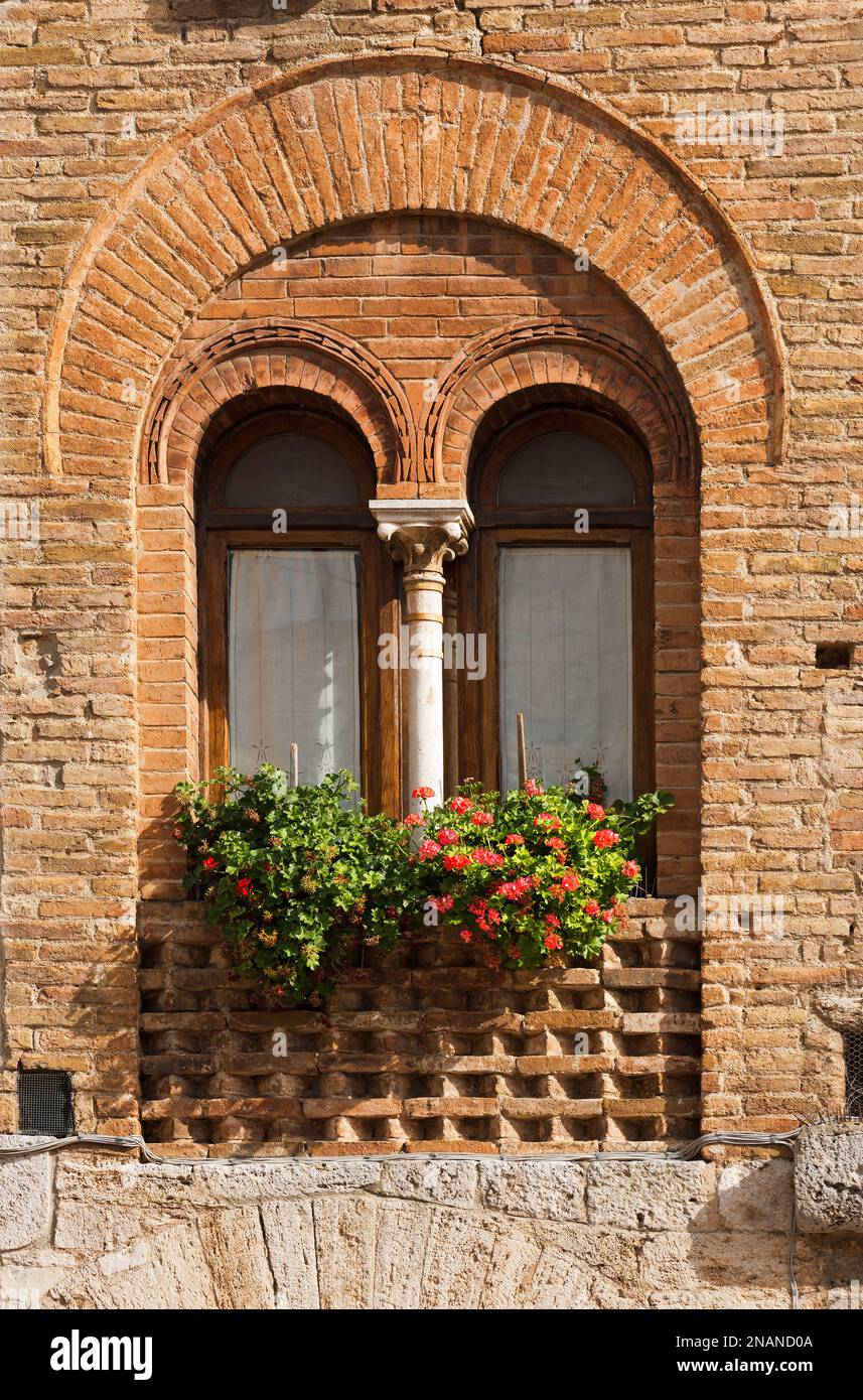 Closeup of a mullioned window on medieval brick wall in San Gimignano ...