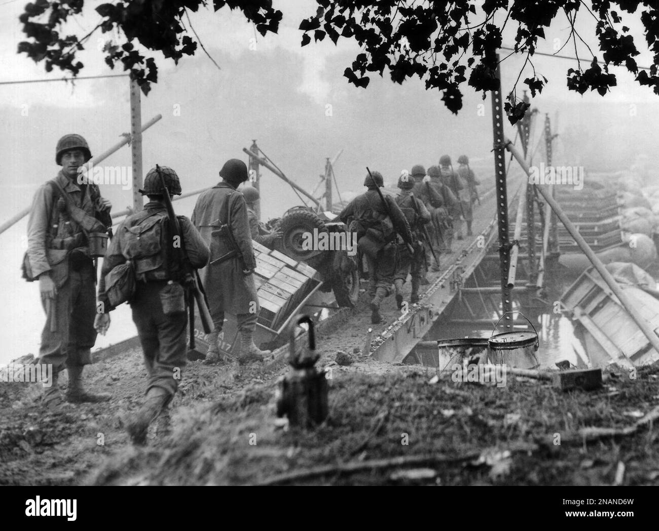 American infantrymen slush through mud to cross the Moselle river into ...