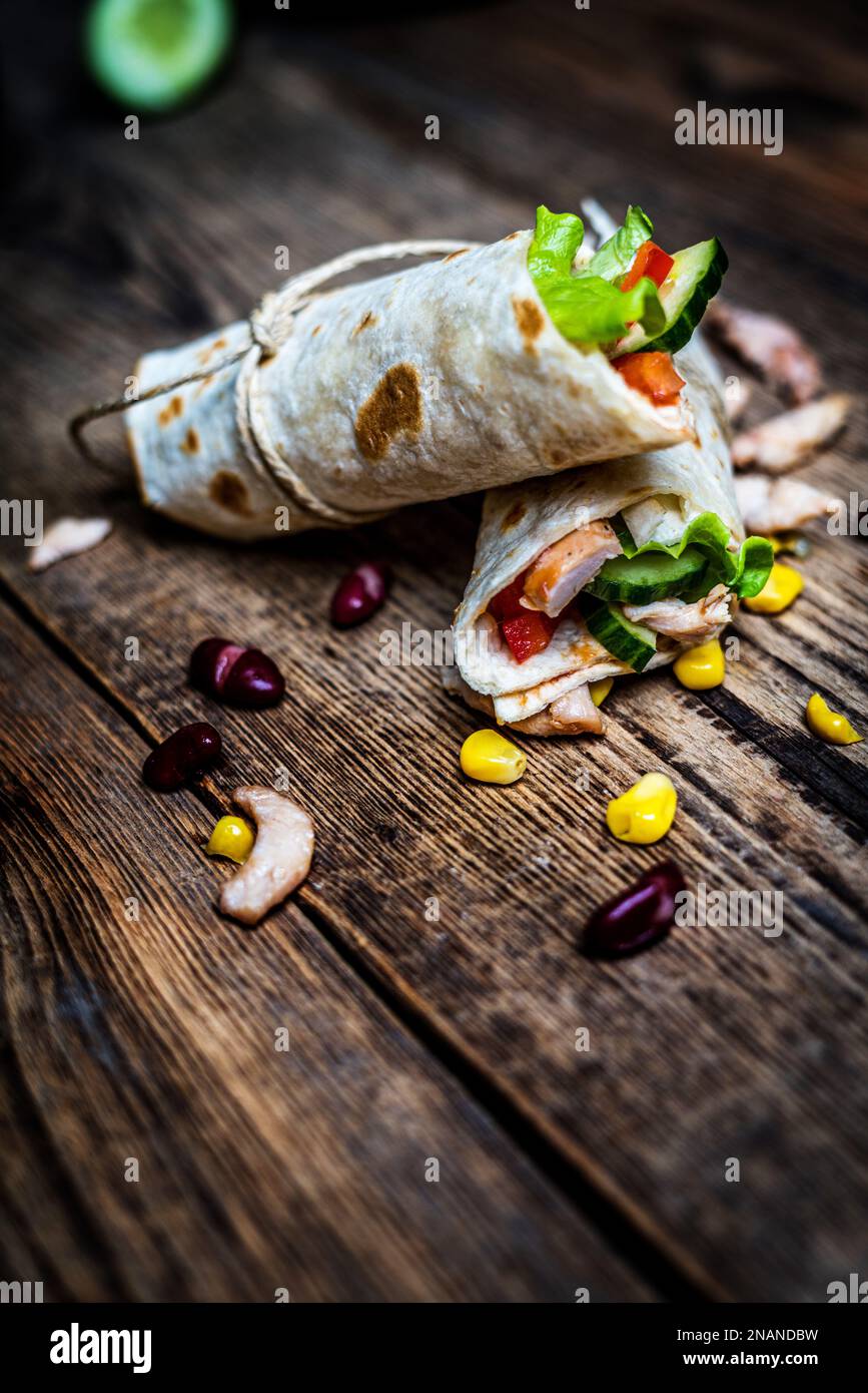 Traditional mexican tortilla wrap with chicken meat and vegetables on ...
