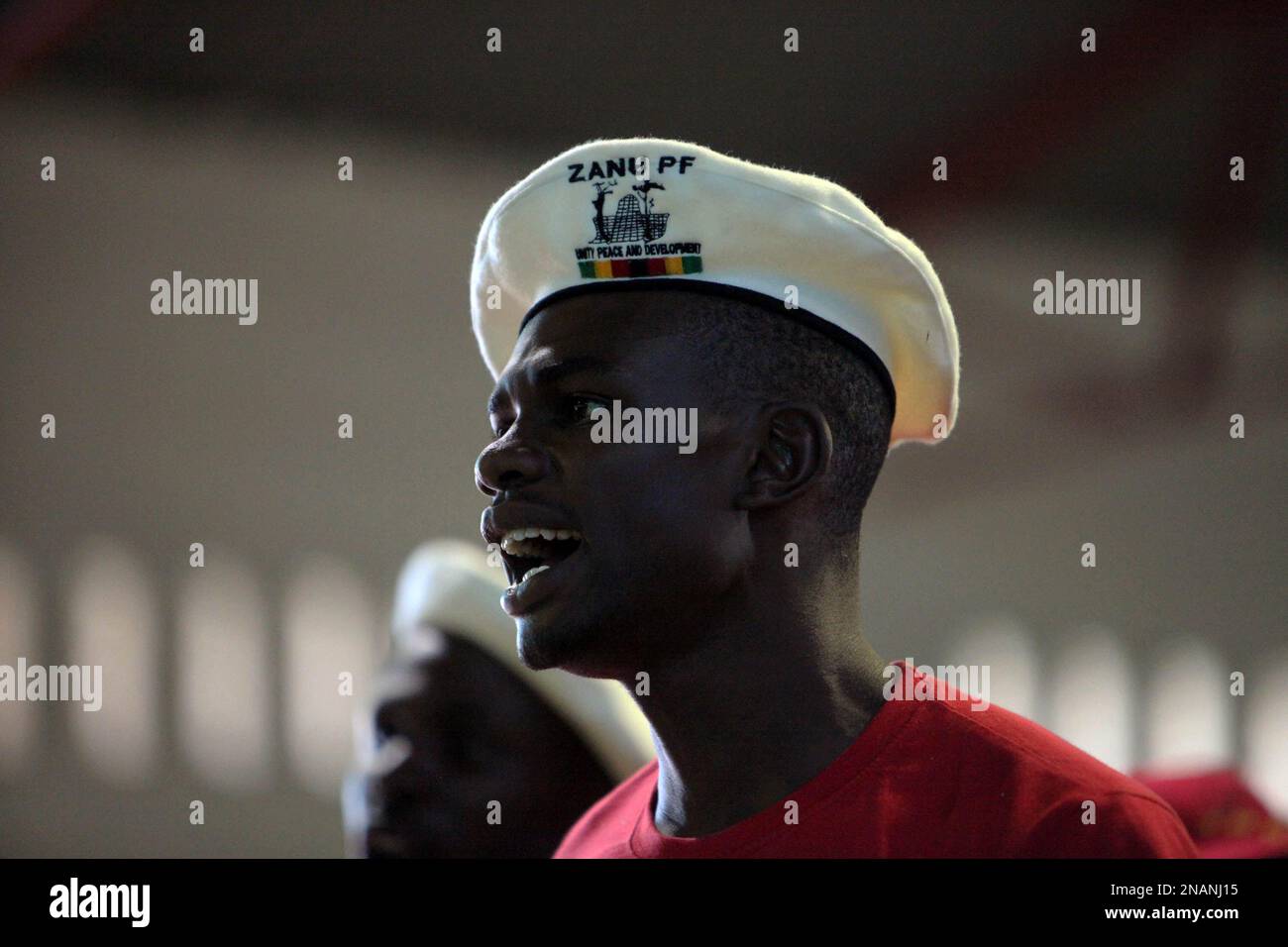 A supporter of Zimbabwe's President Robert Mugabe takes time to sing ...