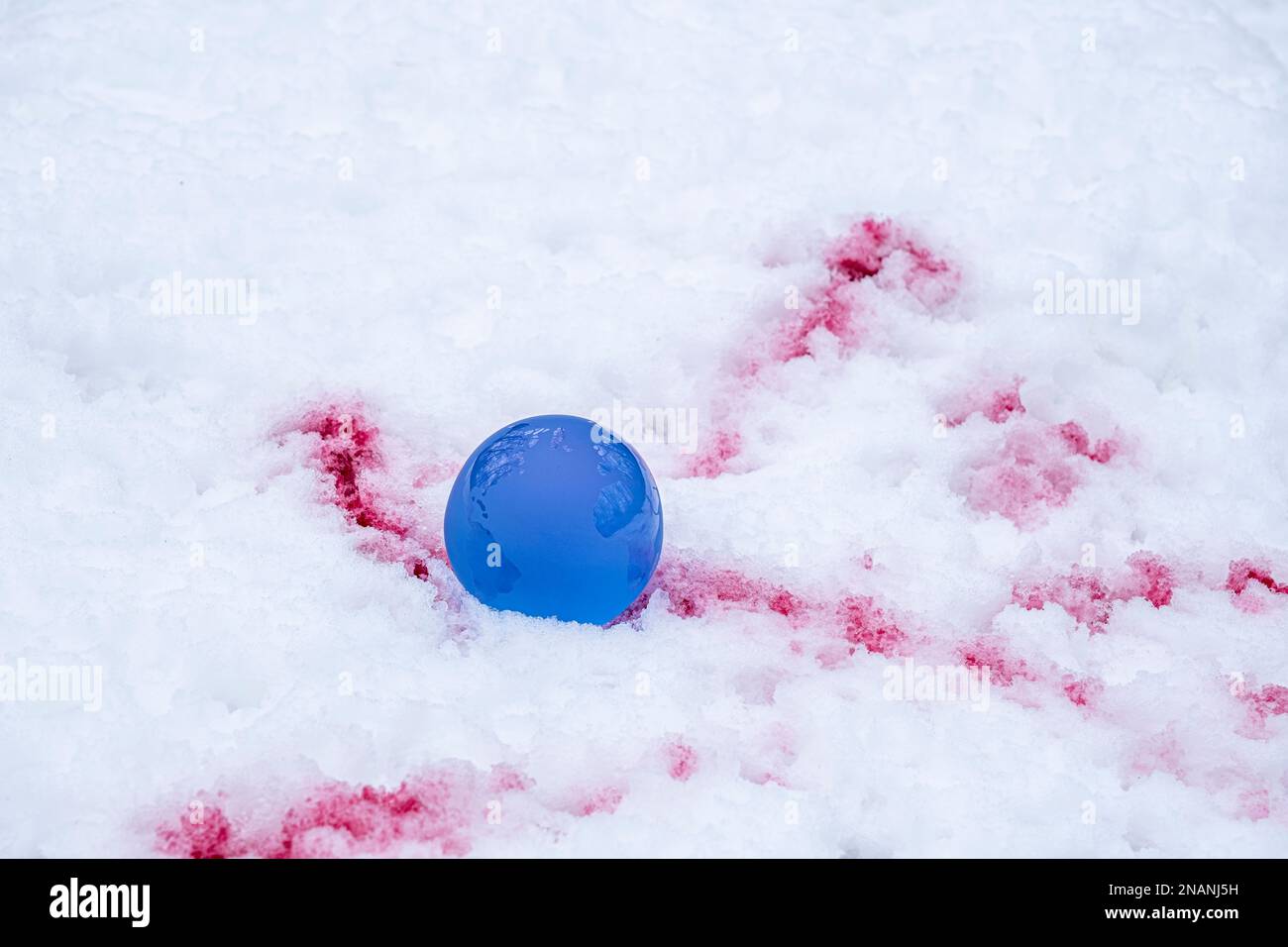 The concept of symbolism. crystal earth globe on snow with blood stains ...