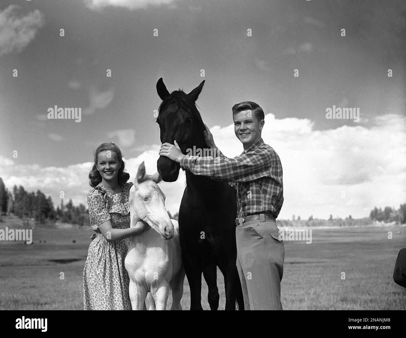 Screen actress Peggy Cummins puts her arms around the neck of the all ...