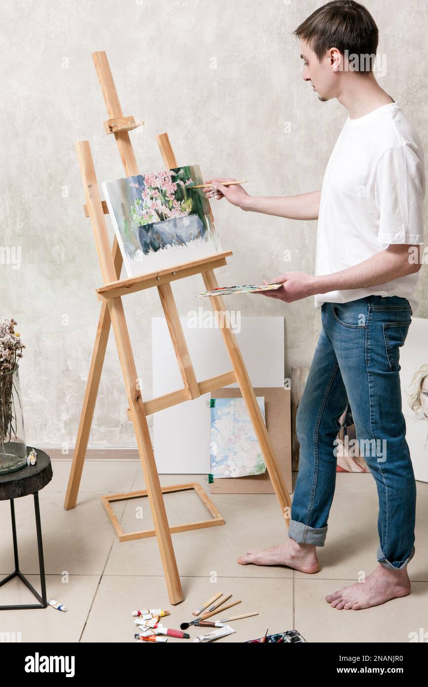 Artist draws a beautiful painting on easel Stock Photo - Alamy