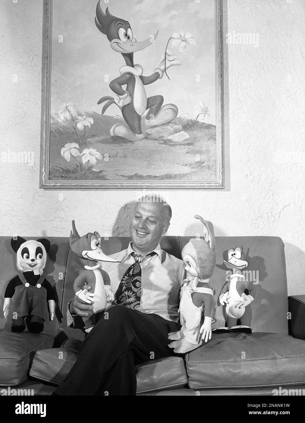 Animated cartoon motion picture producer Walter Lantz sits with dolls ...