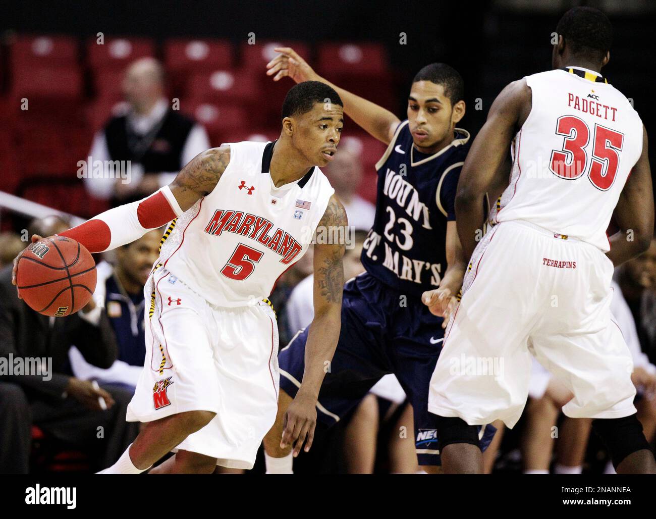 Maryland guard Nick Faust (5) drives past Mount St. Mary's guard Julian ...