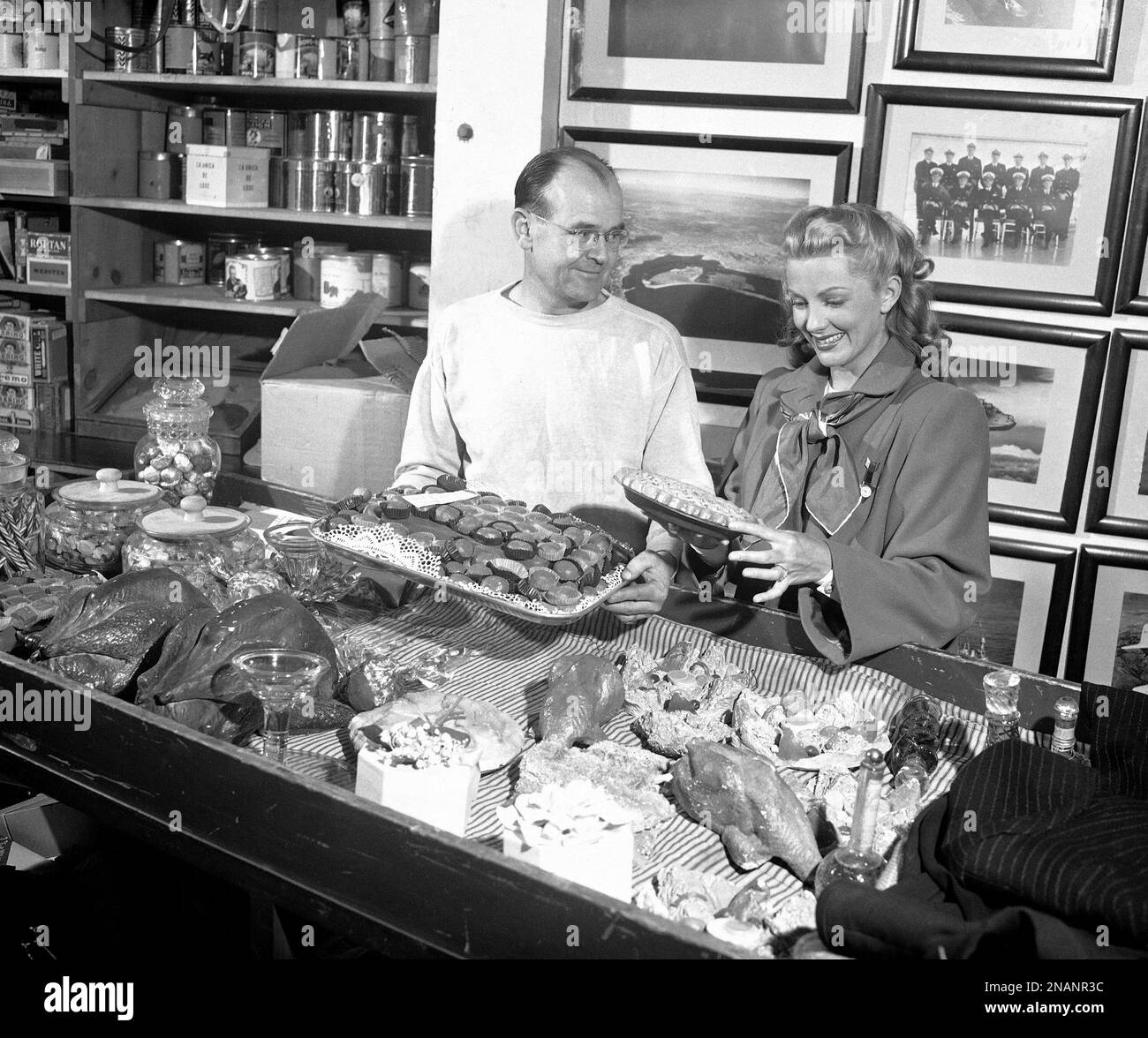 Actress Phyllis Coates inspects an enticing display of delicacies on a ...