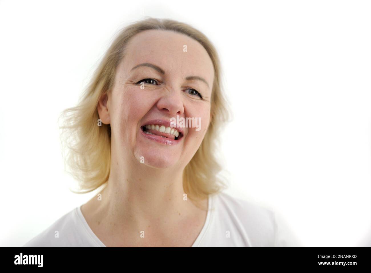 sincere smile of a beautiful woman glowing eyes close-up face on white background teeth ajar ...