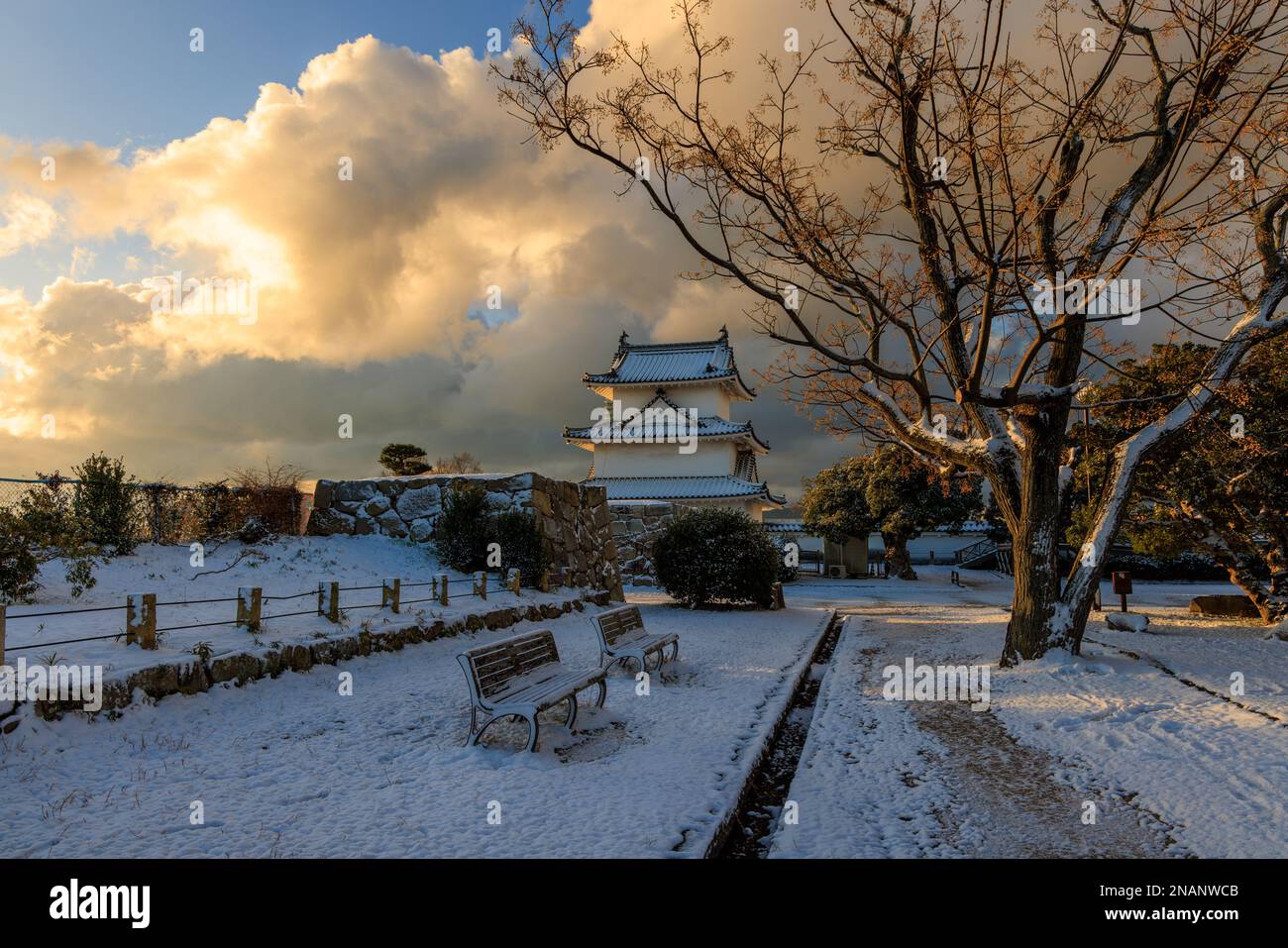Sunrise light on clouds and historic Japanese castle in snow covered ...