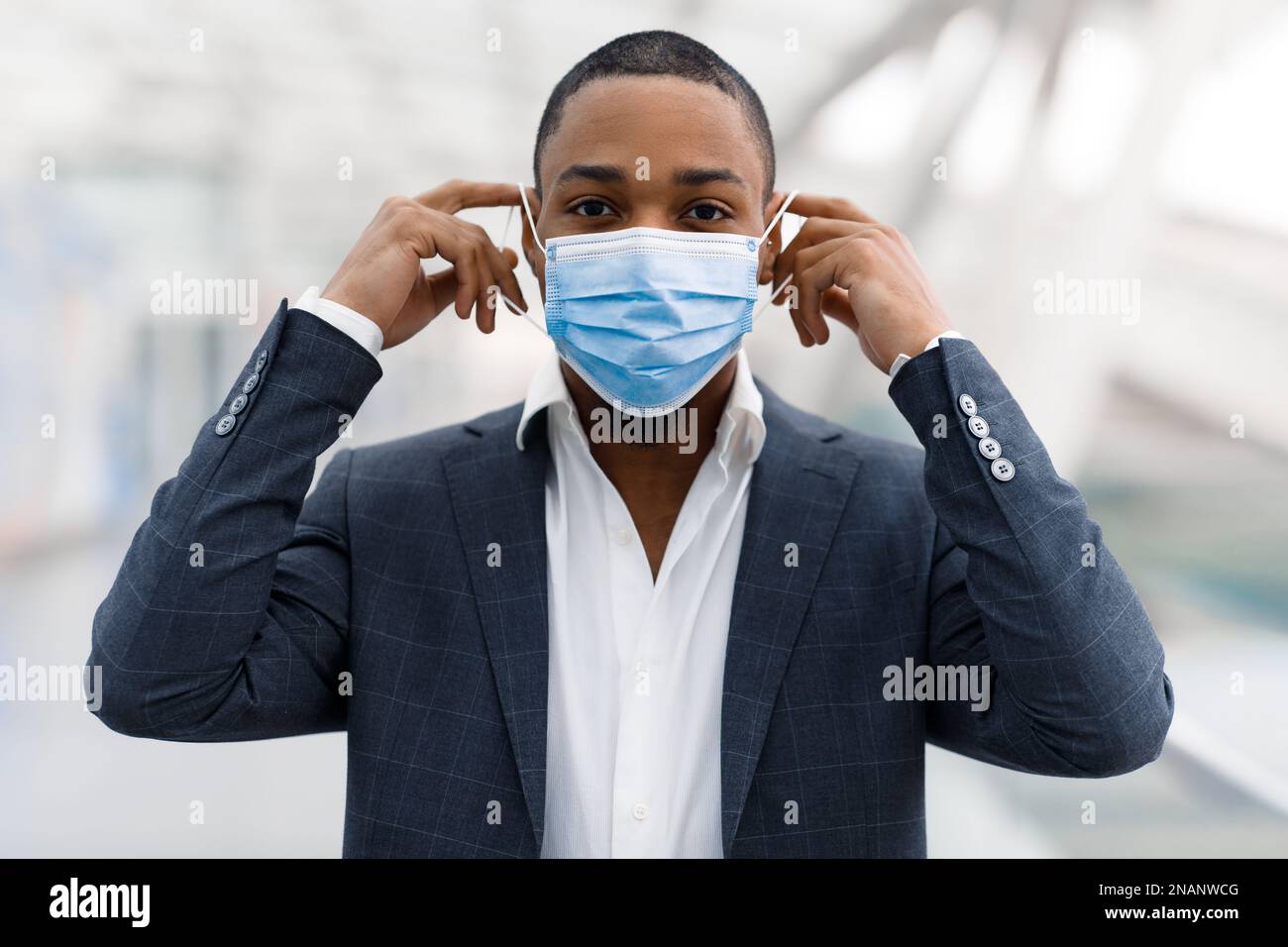 Closeup portrait of black businessman pulling medical mask over his ...