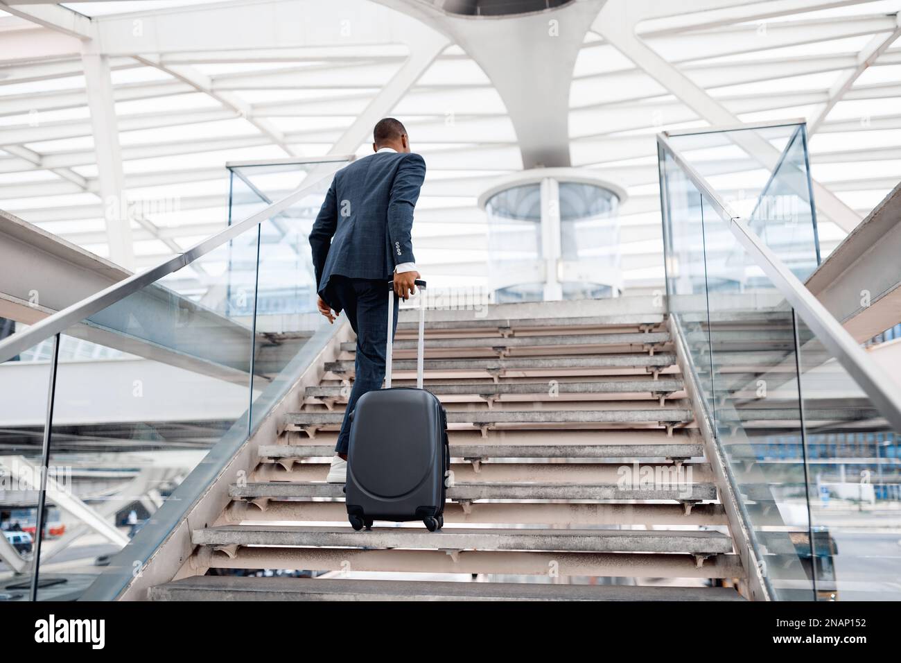 Black Businessman With Suitcase Walking Up Stairs At Airport Terminal ...