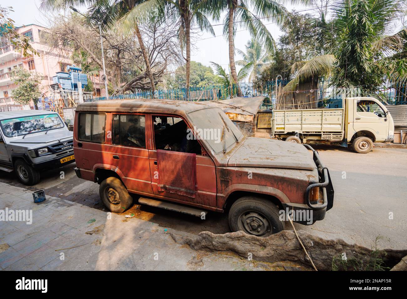 A rusty battered old car or van (a Tata Sumo) parked in the street in ...