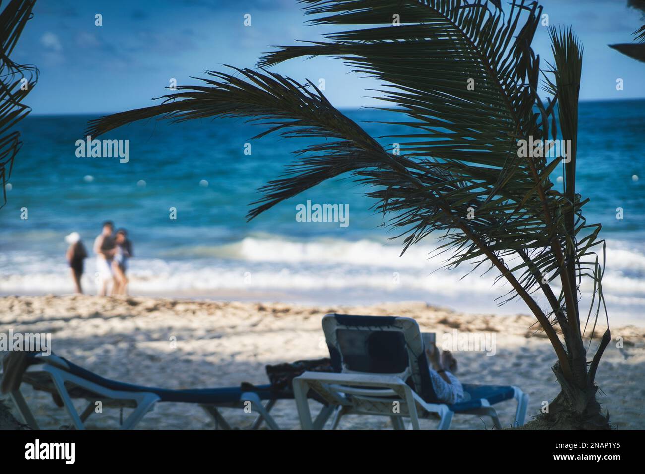 A sunlit beach in Punta Cana on a sunny day, people walking around ...