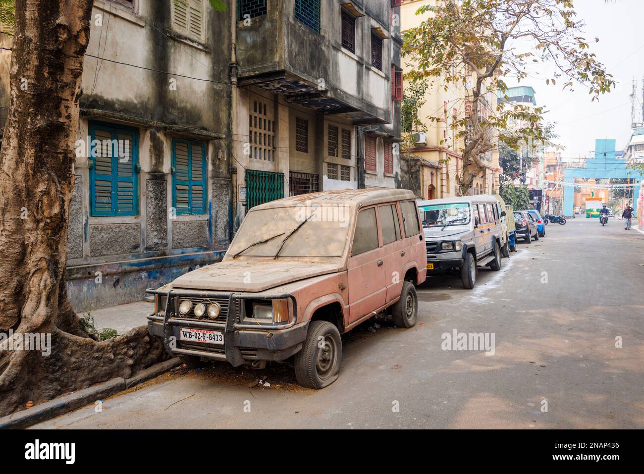 A rusty battered old car or van (a Tata Sumo) parked in the street in ...