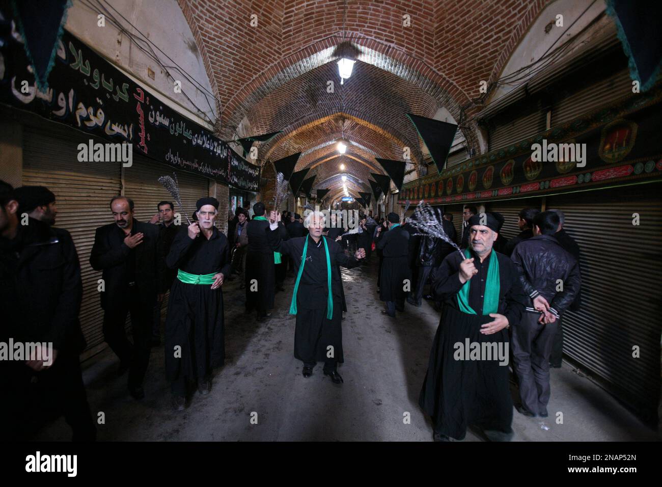 Black-dressed Iranian Shiite Muslims beat their shoulders with iron ...