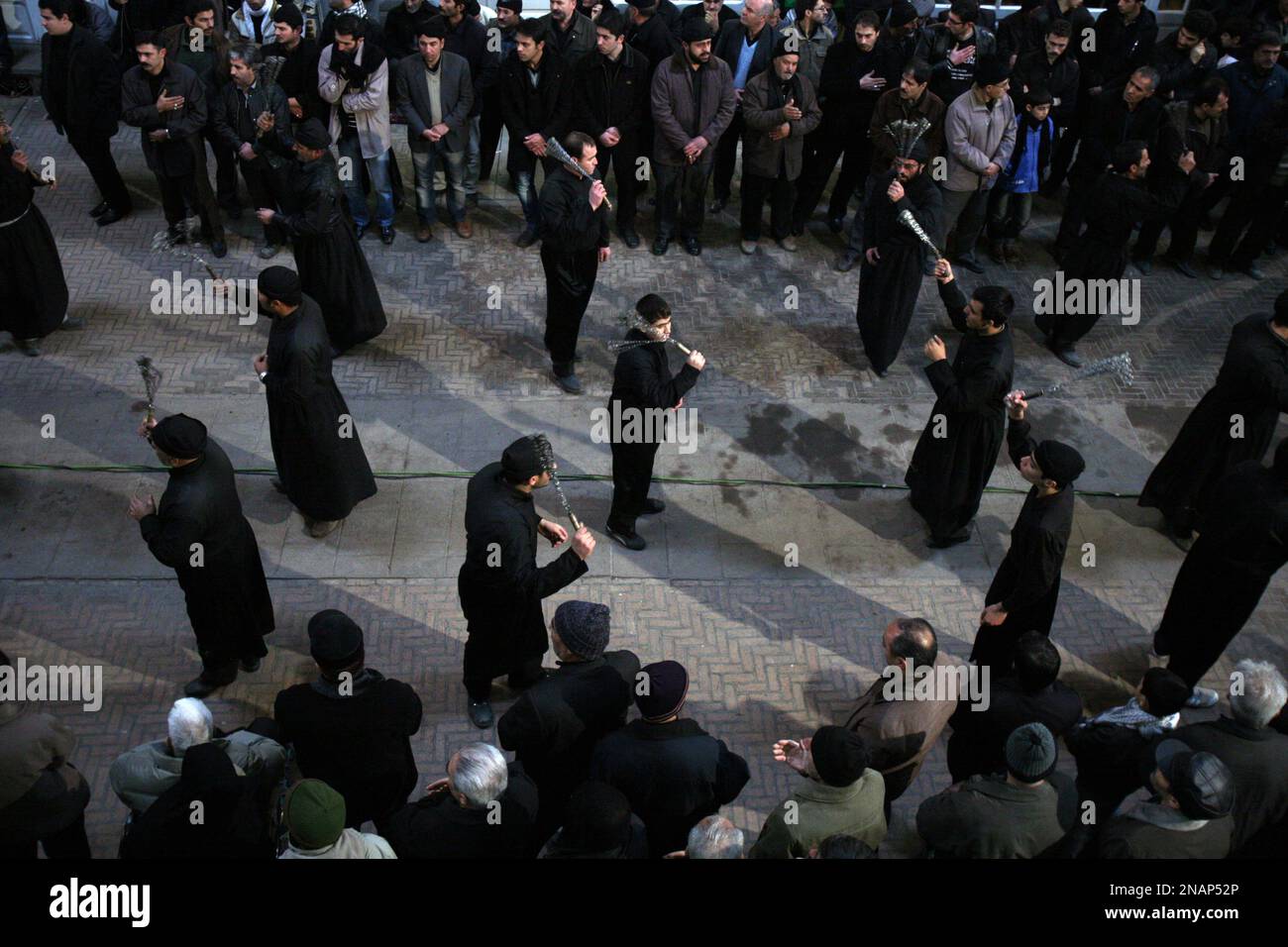 Black-dressed Iranian Shiite Muslims beat their shoulders with iron ...