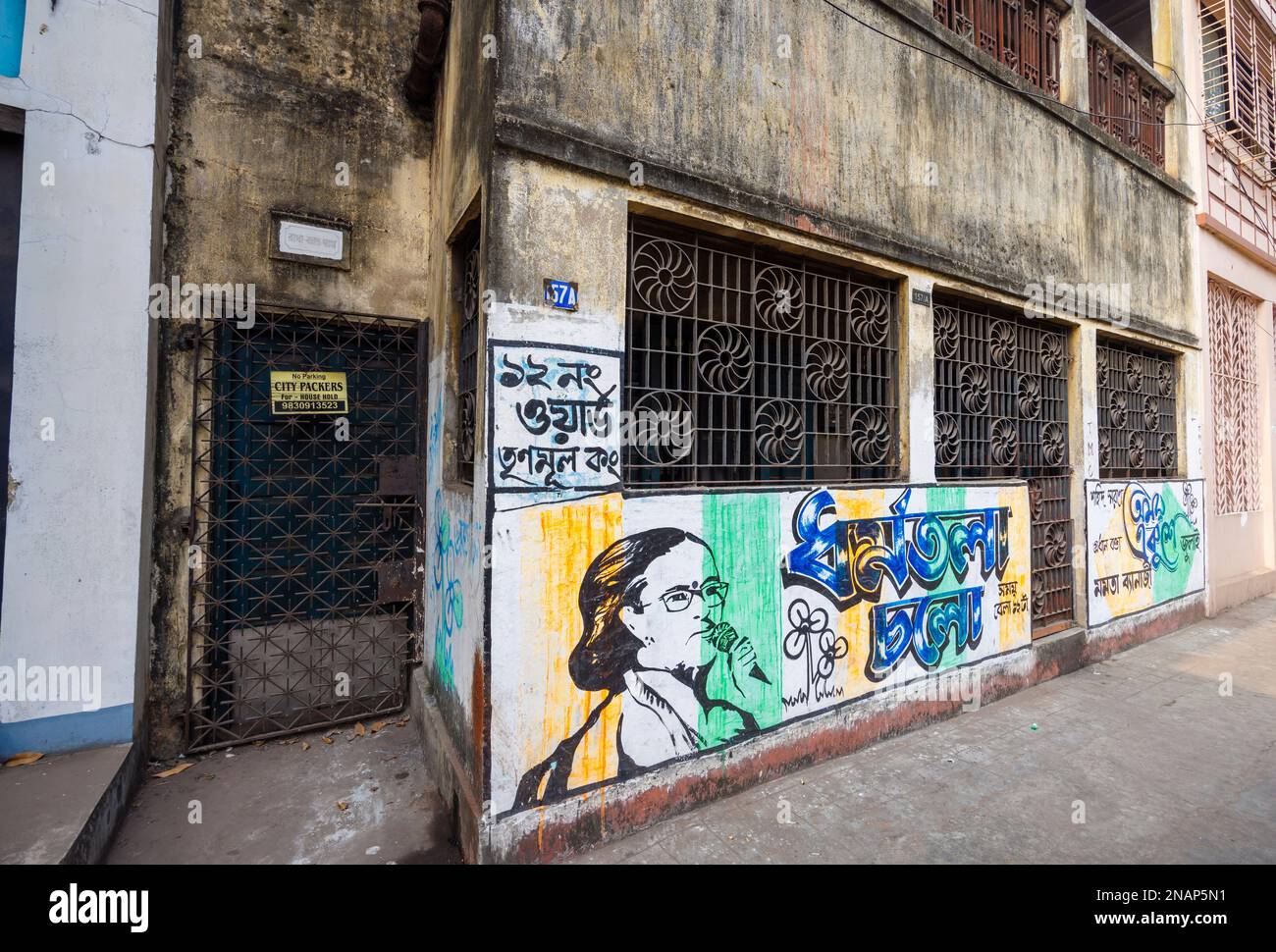 Typical political poster painted on a wall in a street in Fariapukur ...