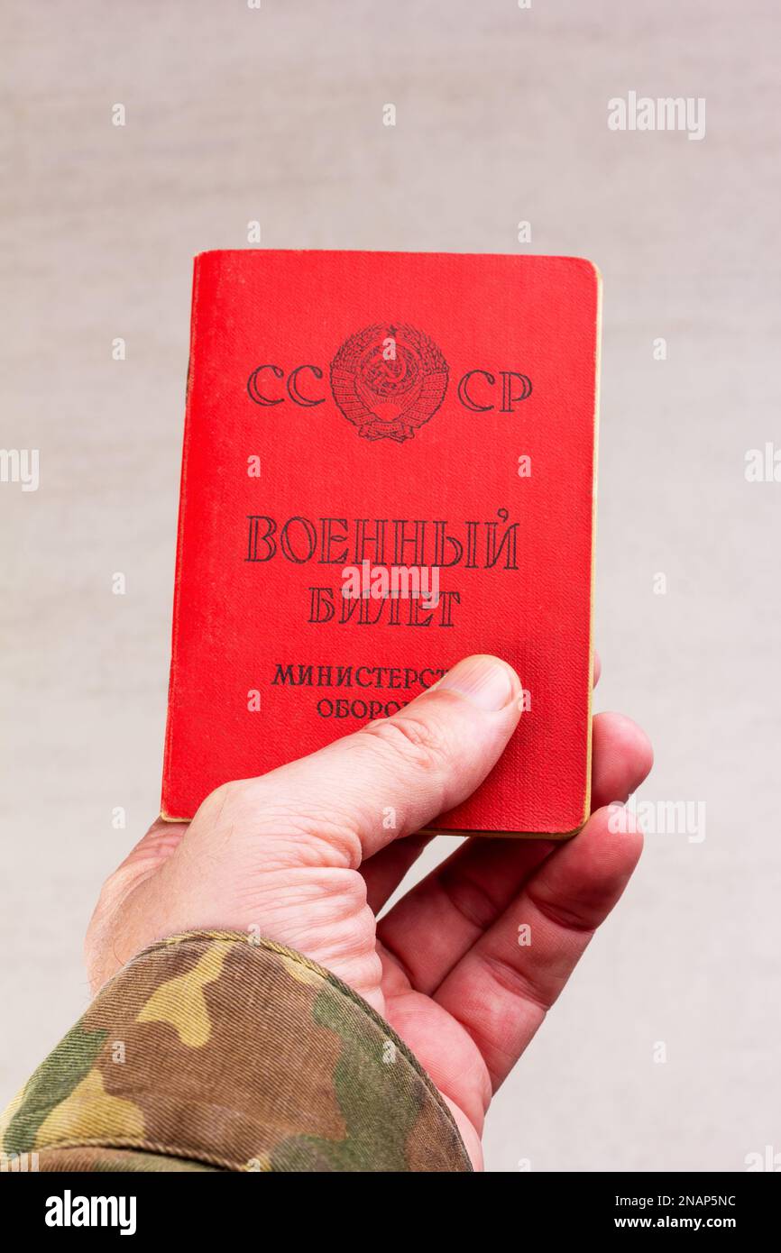 A Soviet military ID card is held in the hand of a man in military ...