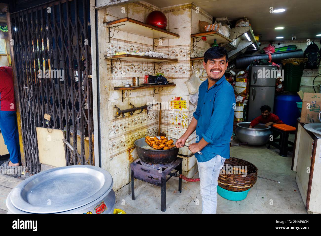 Fried chicken prepared and cooked by a smiling seller in a roadside ...