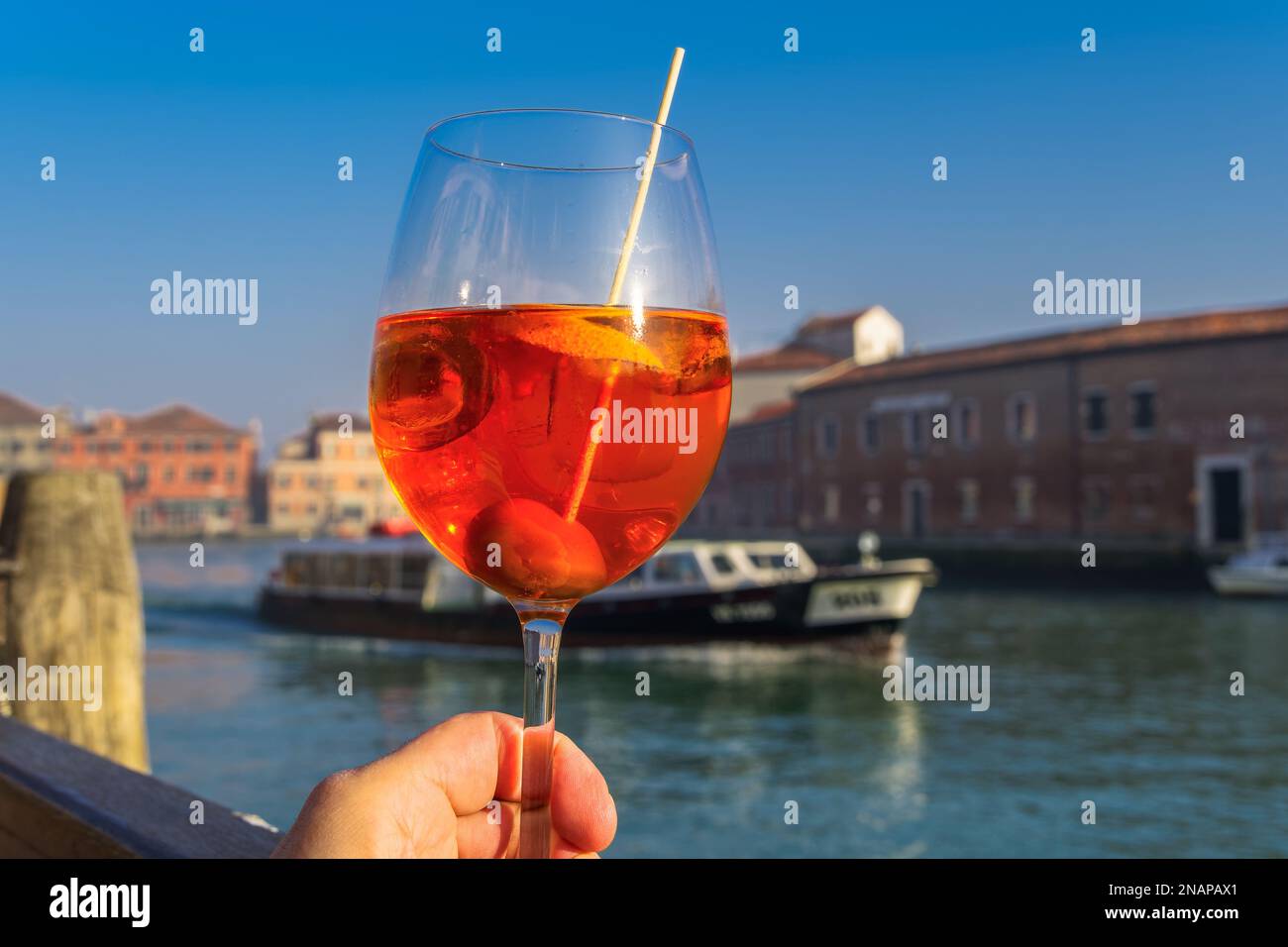 Holding Aperol Spritz aperitif in Italy, at Murano island. Day sunny ...