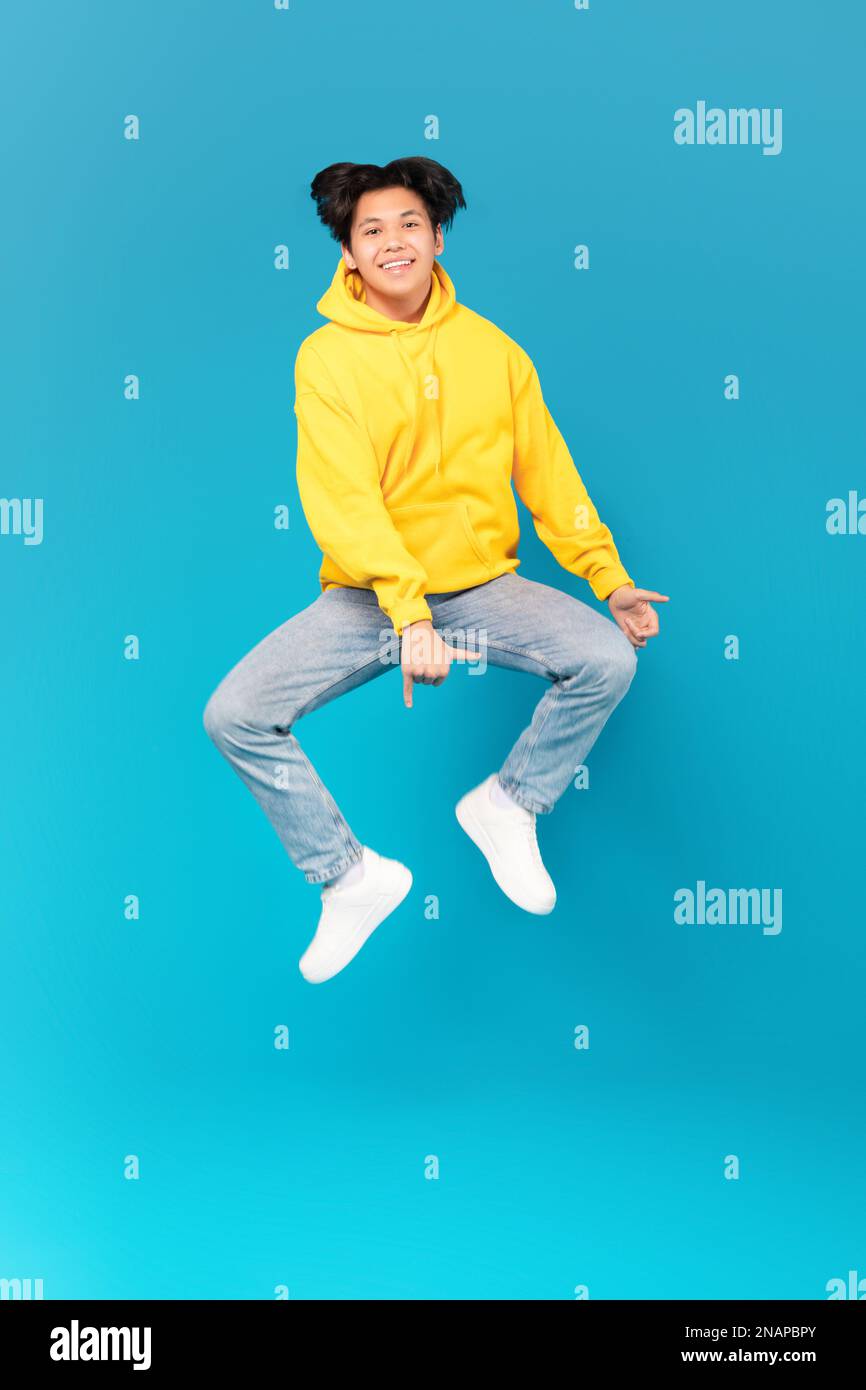 Joyful Asian Teen Boy Jumping Gesturing Shaka Sign, Blue Background ...
