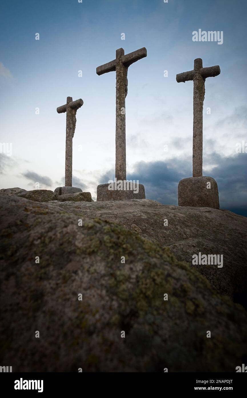 Silhouette of three religious crosses carved in stone with sky at dusk ...