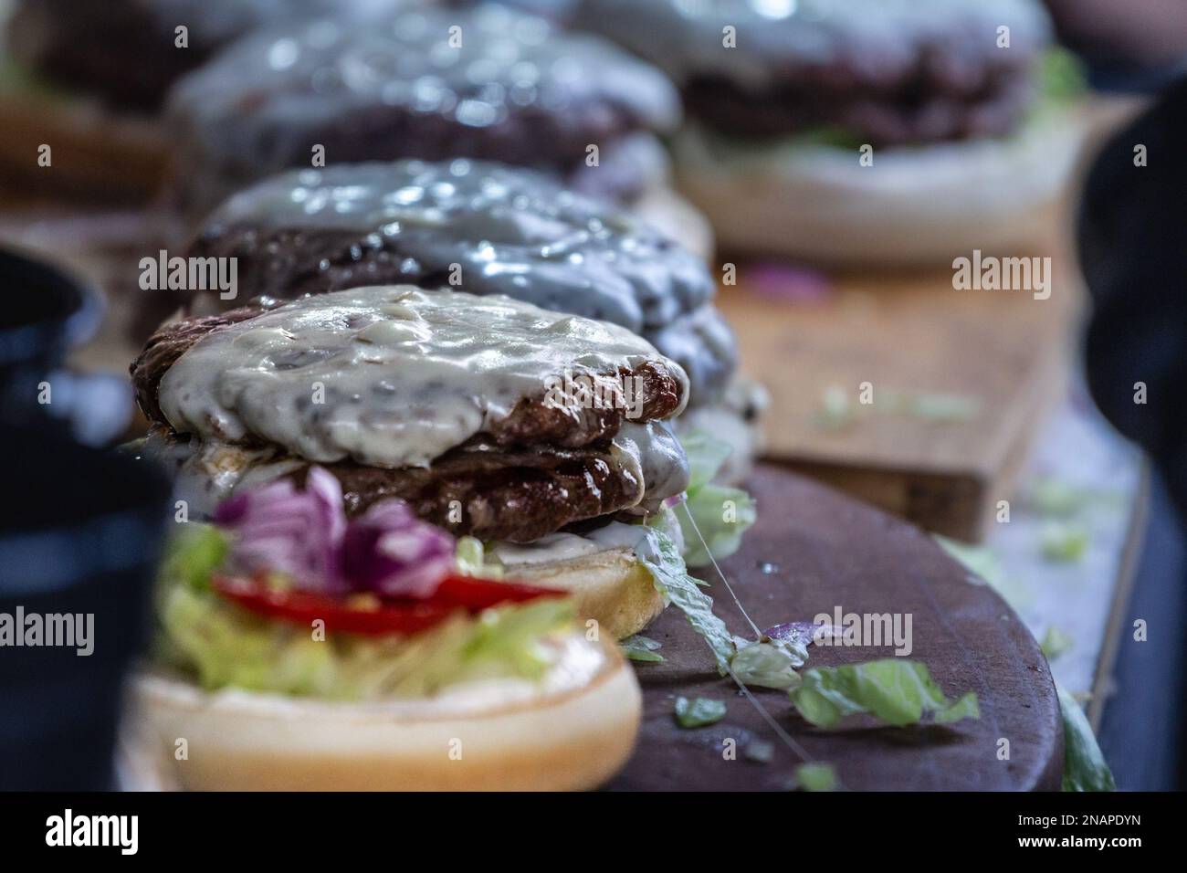 Picture of a bunch of hamburgers, cheesburgers, ready to get assembled ...