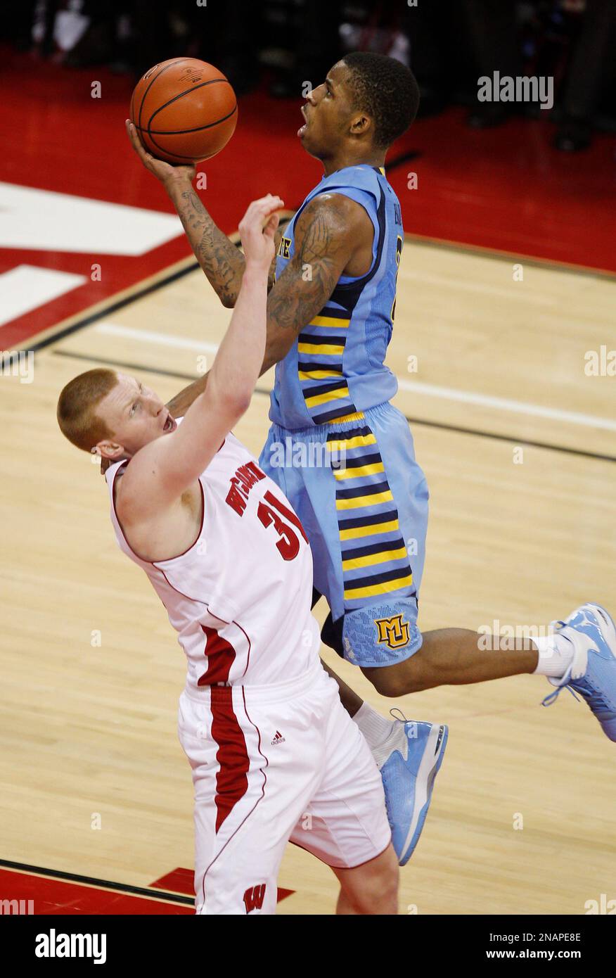 Marquette's Vander Blue, right, shoots past Wisconsin's Mike Bruesewitz ...