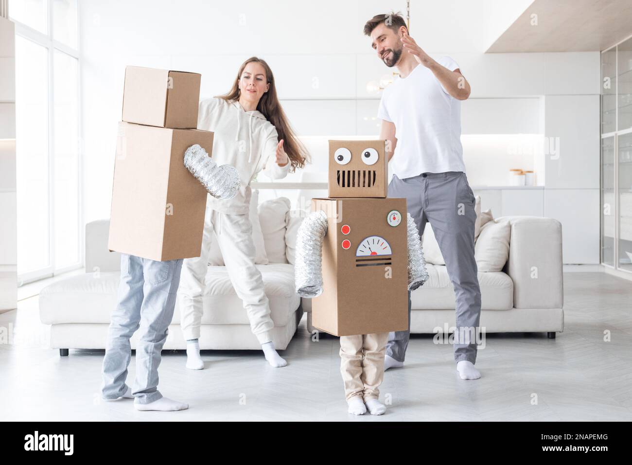 Happy family of parents and two children playing dancing like robots at ...