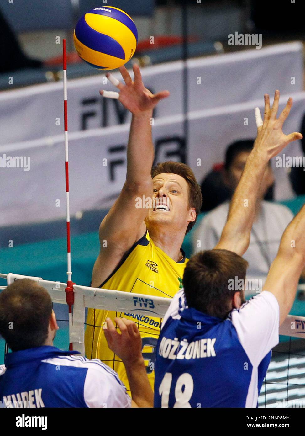 Murilo Endres of Brazil spikes the ball against Bartosz Kurek, left ...
