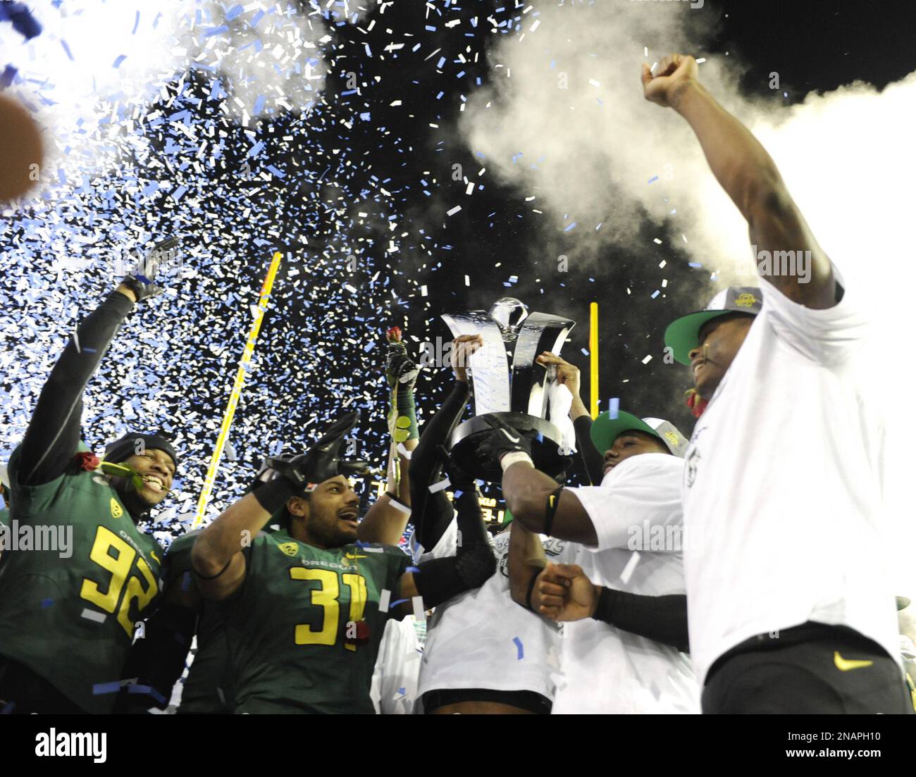 Oregon players hold up the trophy as they celebrate their 49-31 win ...