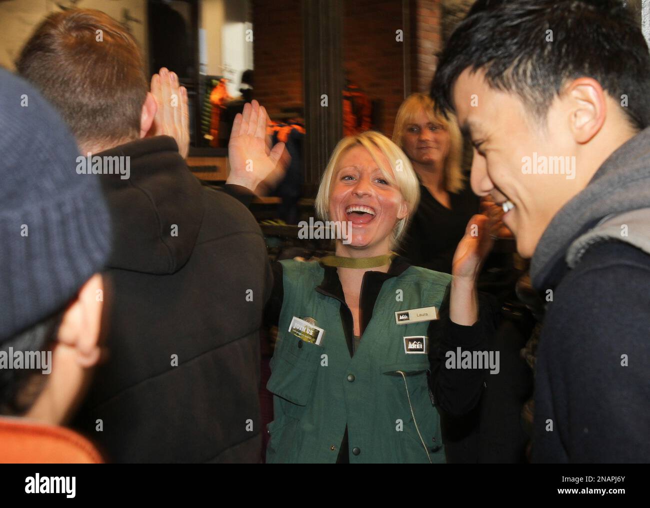 REI Employees in green welcome shoppers to the REI (Recreational ...