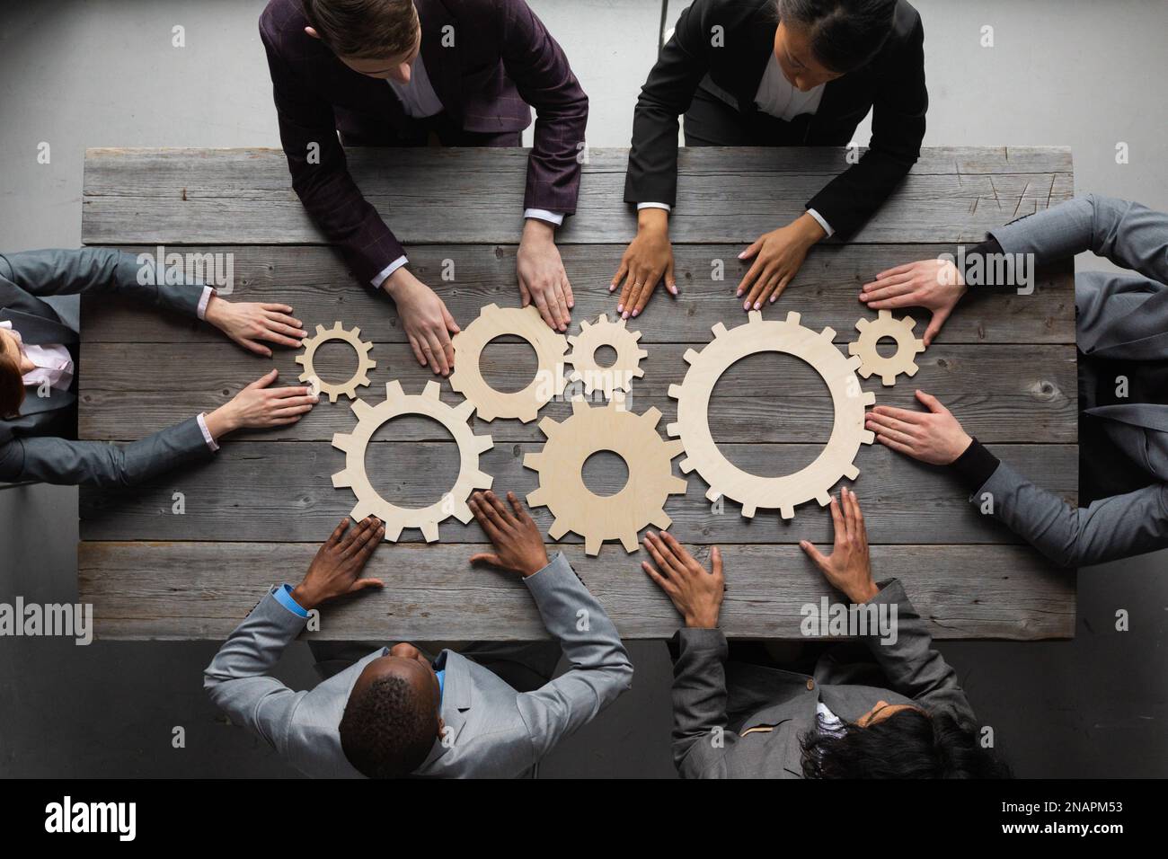 Business people connect golden gear together at meeting table, success ...