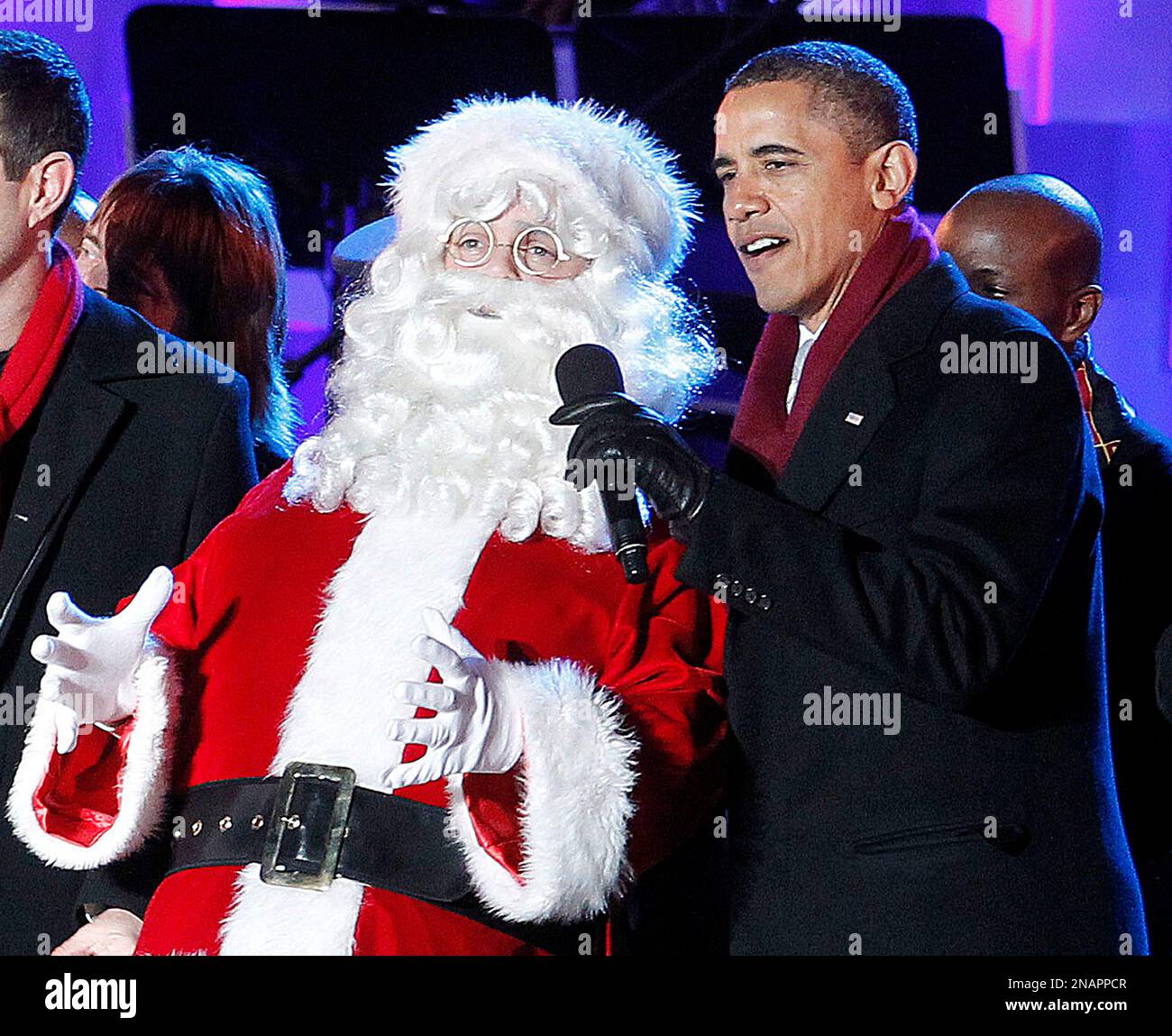 President Barack Obama, far right, and sings on stage with Santa Claus ...