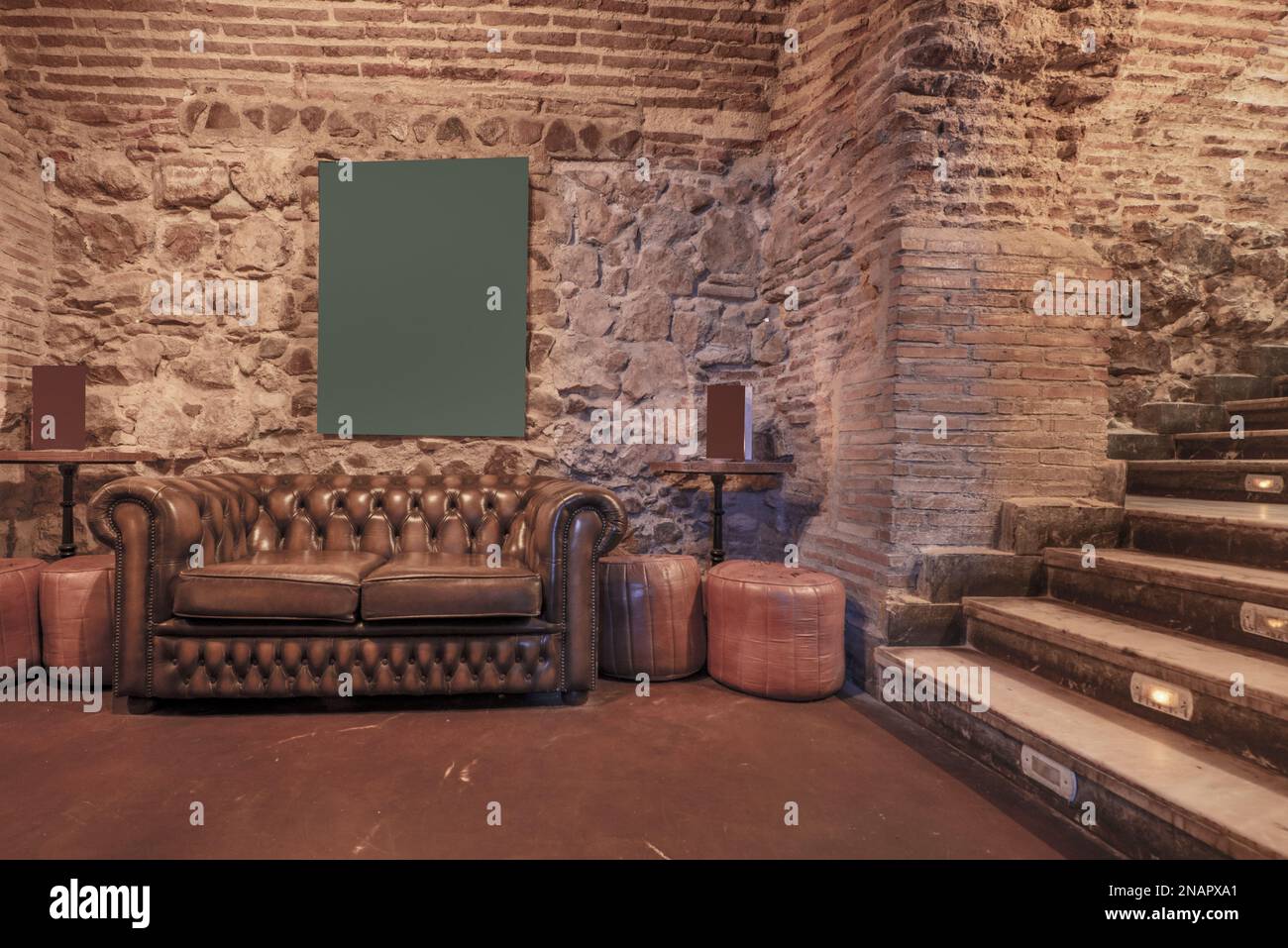 Living room of a nightlife venue with a shiny brown leather chester ...