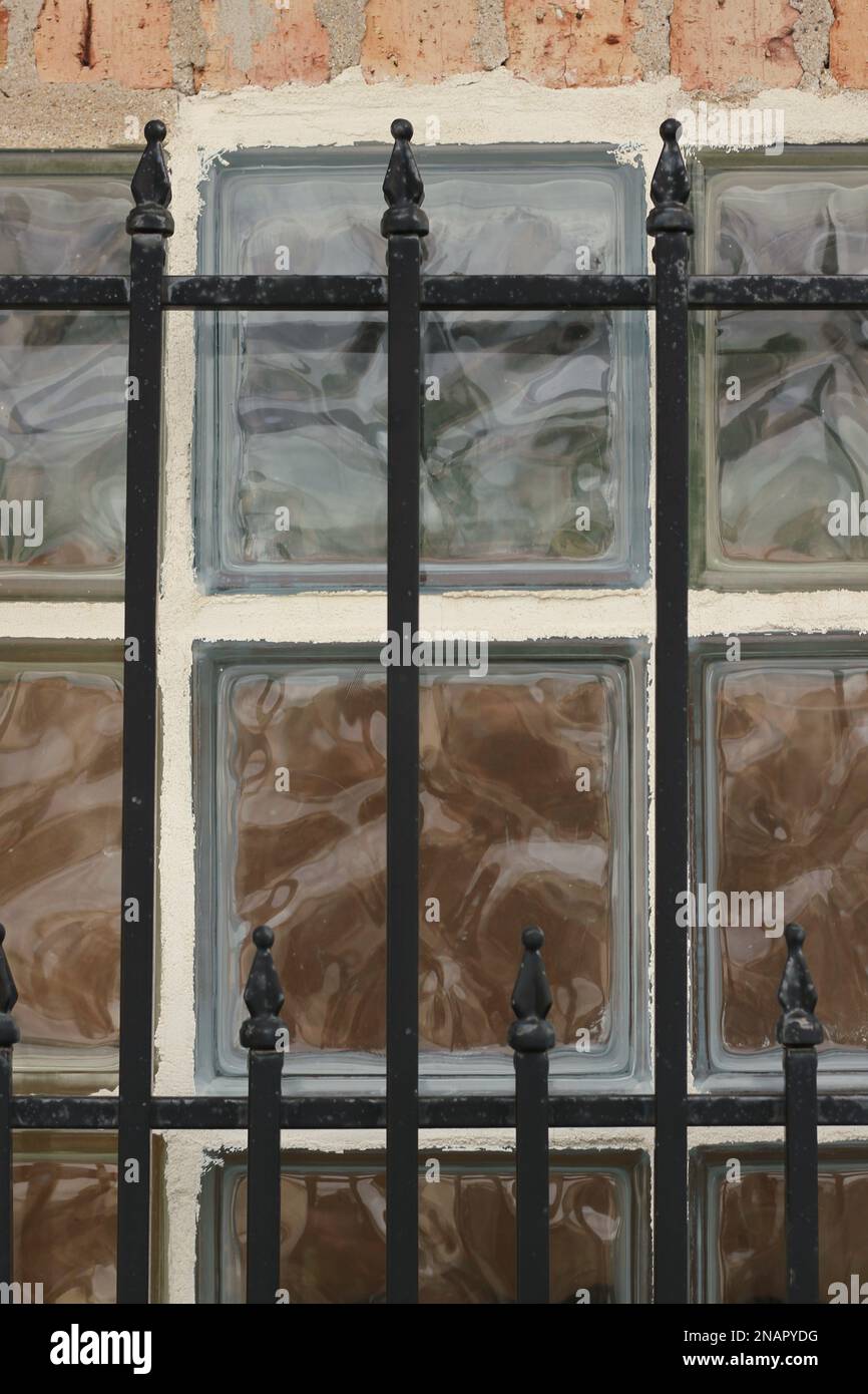 A wrought iron metal security fence protecting a glass block window ...
