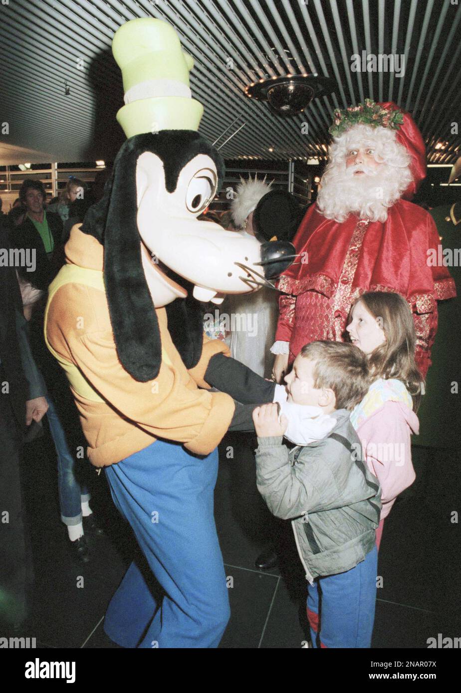 Father Christmas, right, looks on in amazement while Disney character ...