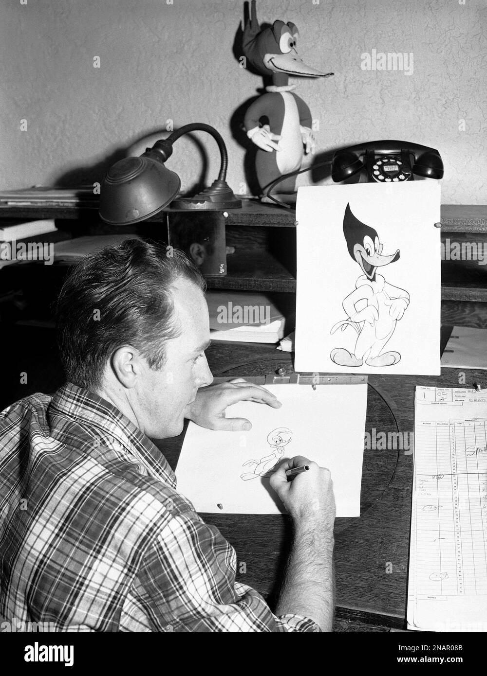 Brad Case works on a drawing of Woody Woodpecker, with model to guide ...
