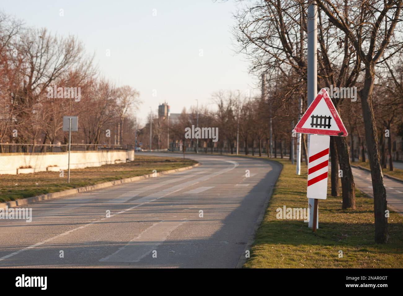 Picture of a European level crossing roadsign standing on an urban road ...