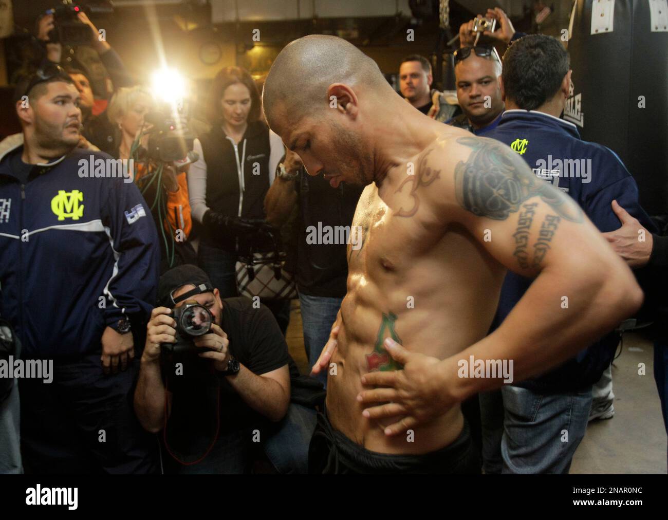 Puerto Rican boxer Miguel Cotto greases his tattooed body before a work ...