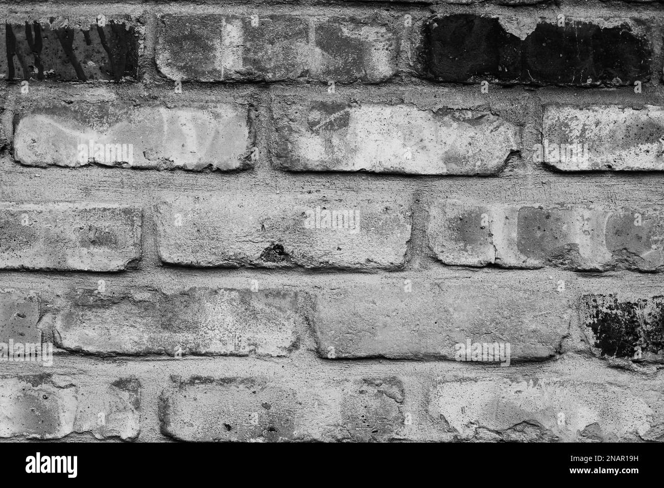 A common typical brick wall with layers of bricks in a black and white ...