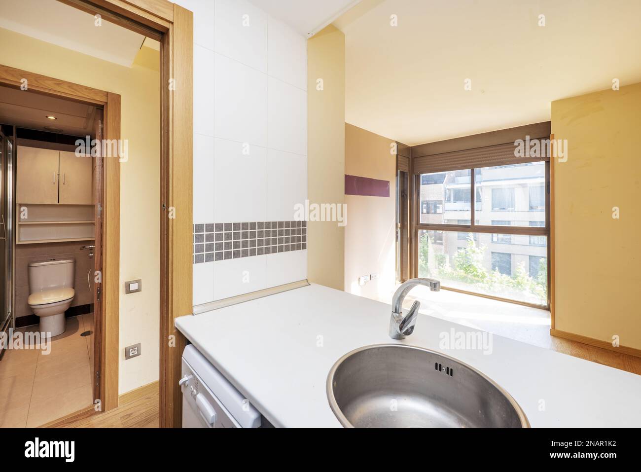 apartment kitchen with white cabinets with matching countertop, pass ...