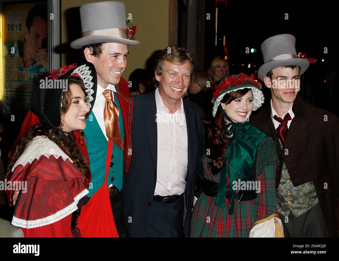 Nigel Lythgoe, center, poses with carolers at the Grand Opening ...