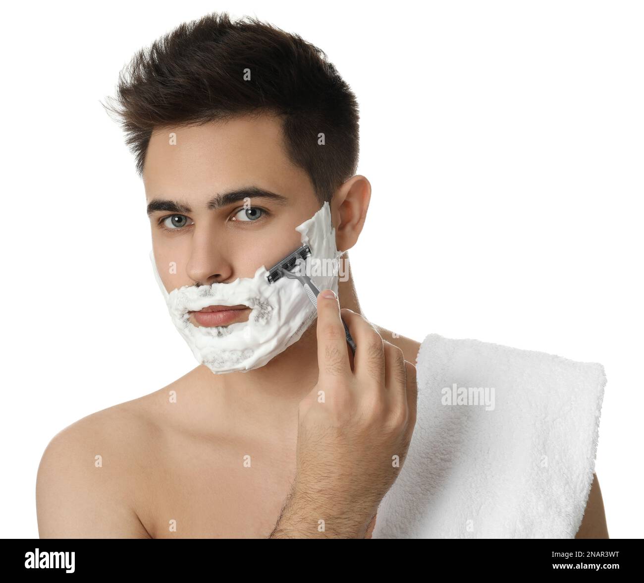 Handsome young man shaving with razor on white background Stock Photo ...
