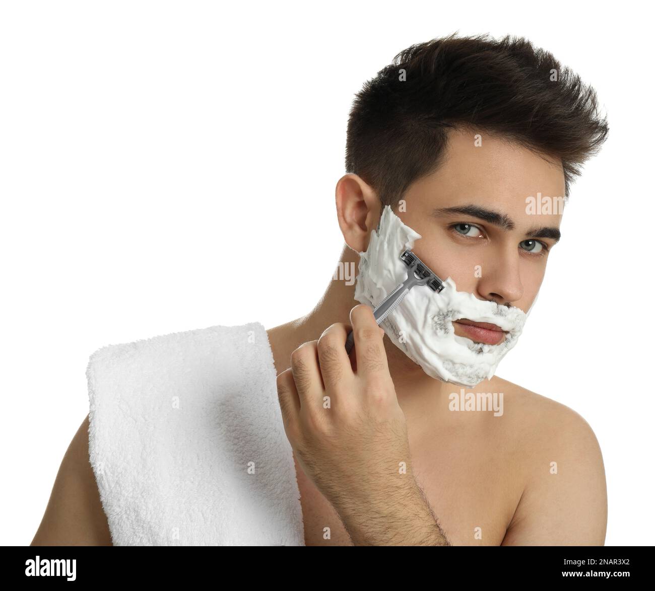 Handsome young man shaving with razor on white background Stock Photo ...