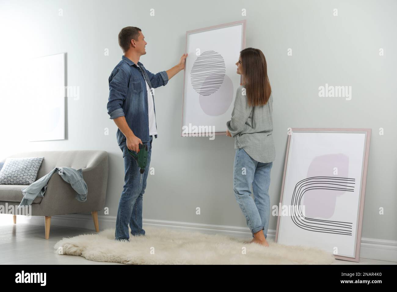Couple decorating room with pictures together. Interior design Stock ...