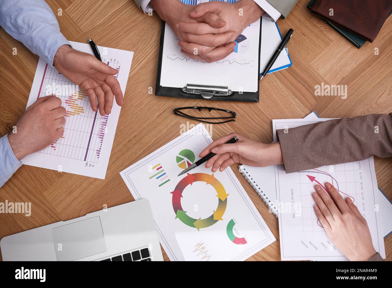 Business people working with charts and graphs at table, top view ...