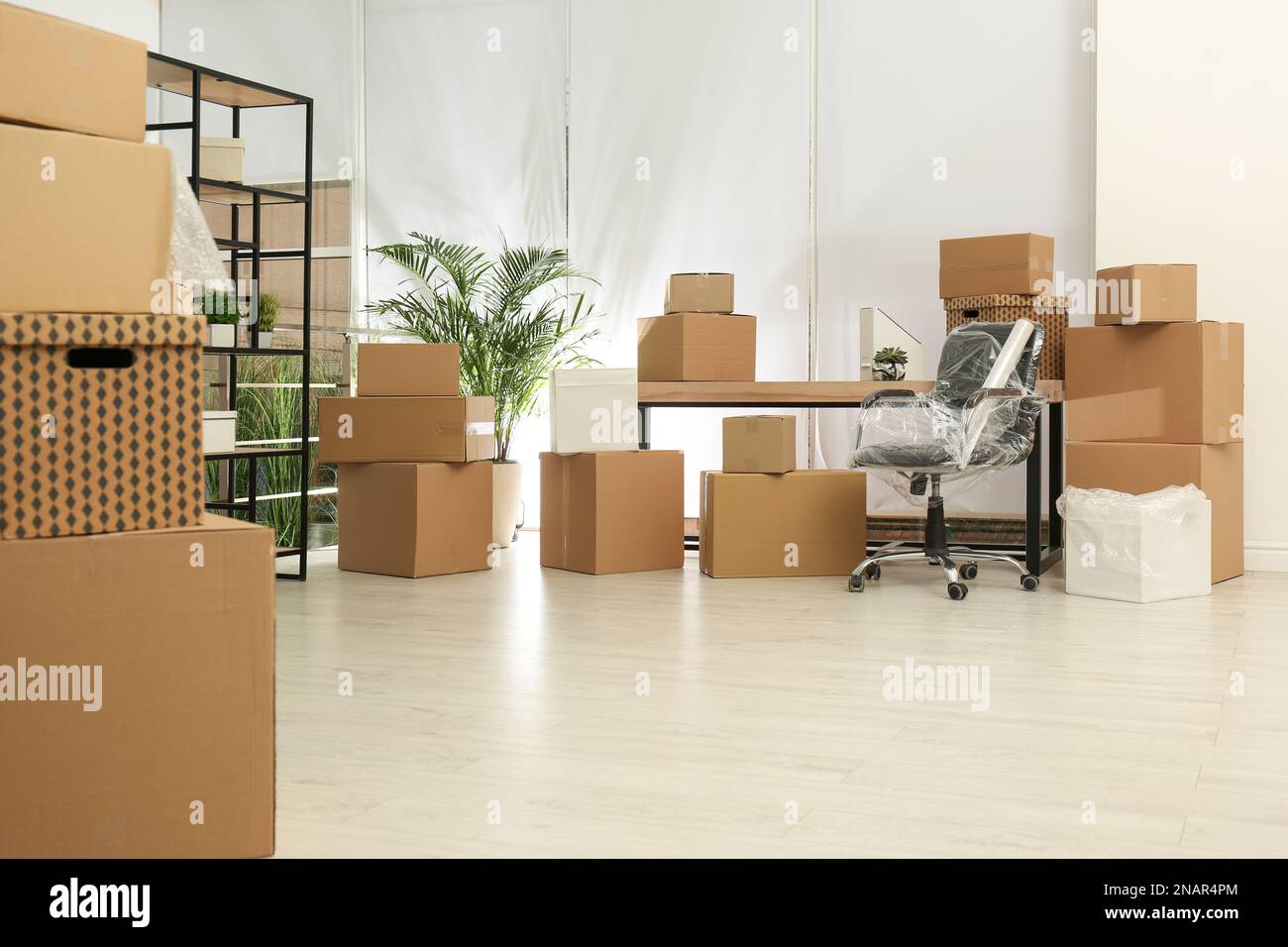 Cardboard boxes and packed chair in office. Moving day Stock Photo - Alamy